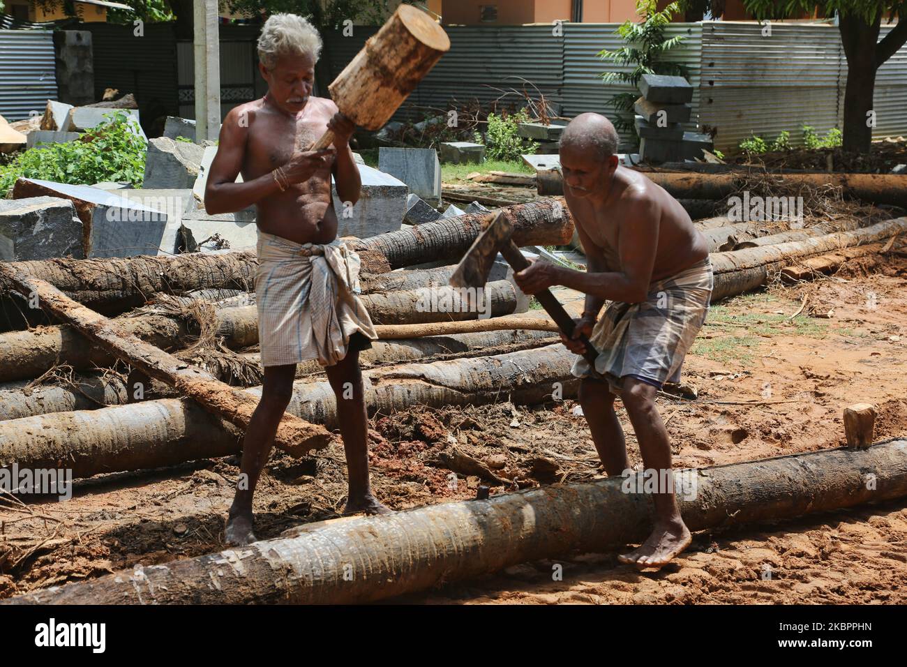 Gli operai usano un'ascia con uno scalpello, un cuneo e un mazzuolo di ...