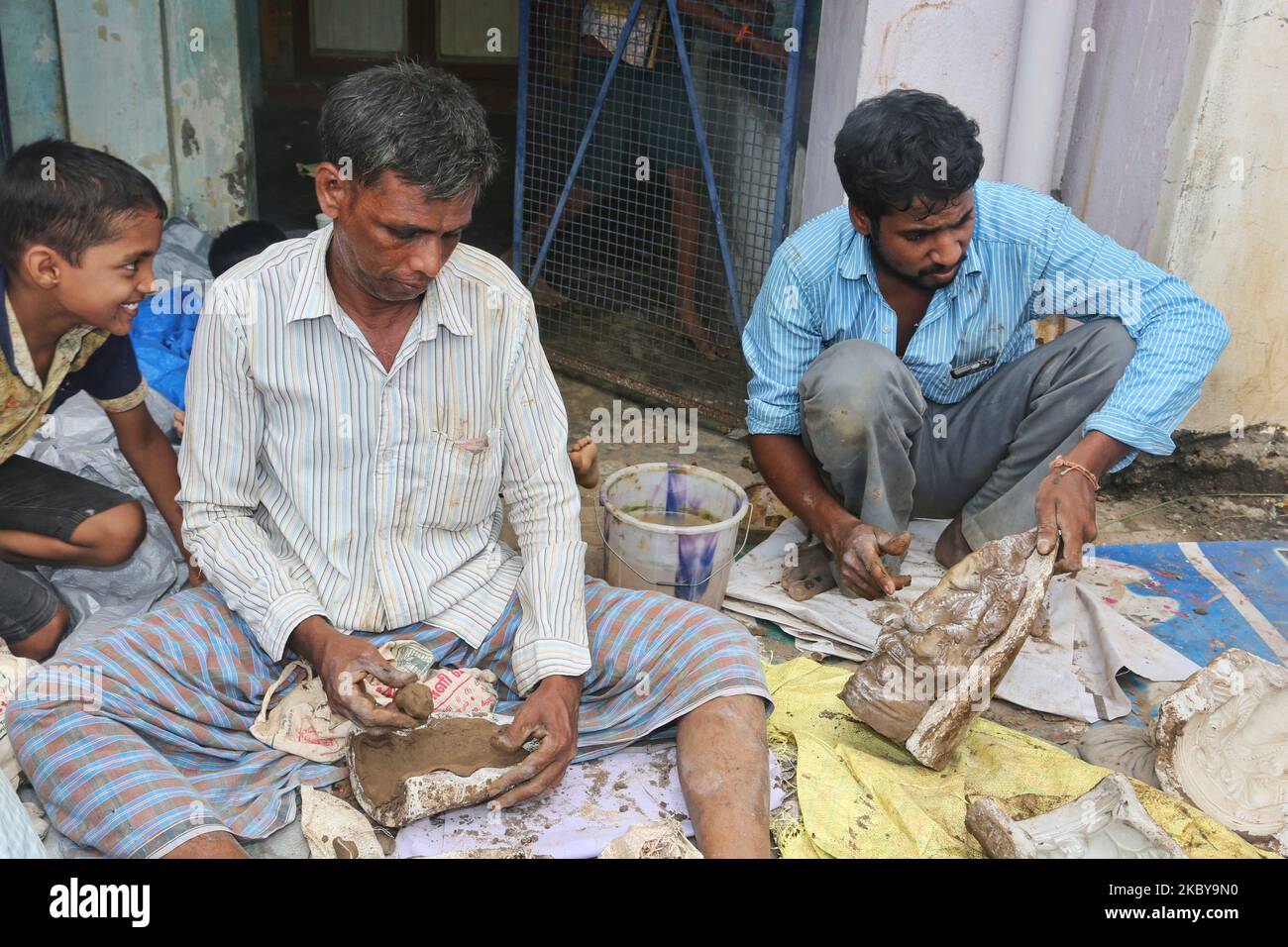 Gli artigiani Tamil tengono stampi riempiti di argilla mentre creano un piccolo idoli di argilla ...