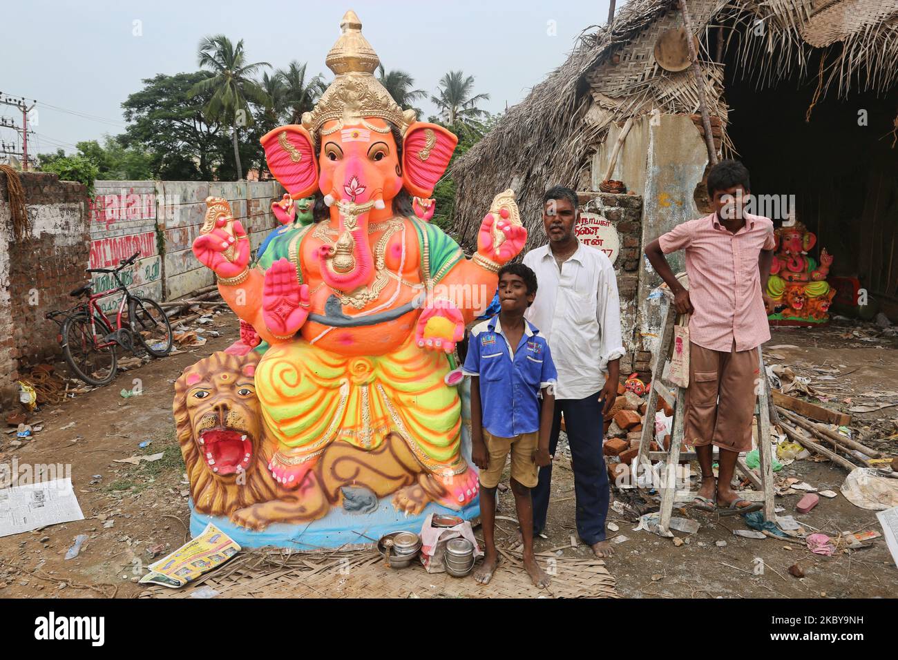 Artigiani stand accanto a un grande idolo di argilla di Lord Ganesha (Signore Ganesh) in un ...