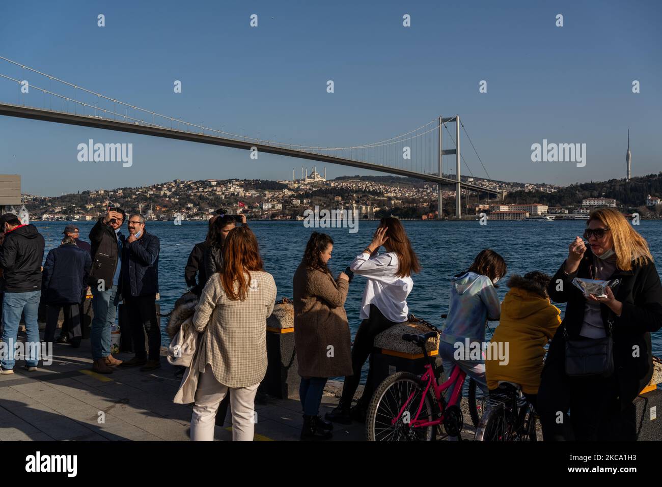 Persone che scattano foto al mare con il Ponte sul Bosforo sullo sfondo ...