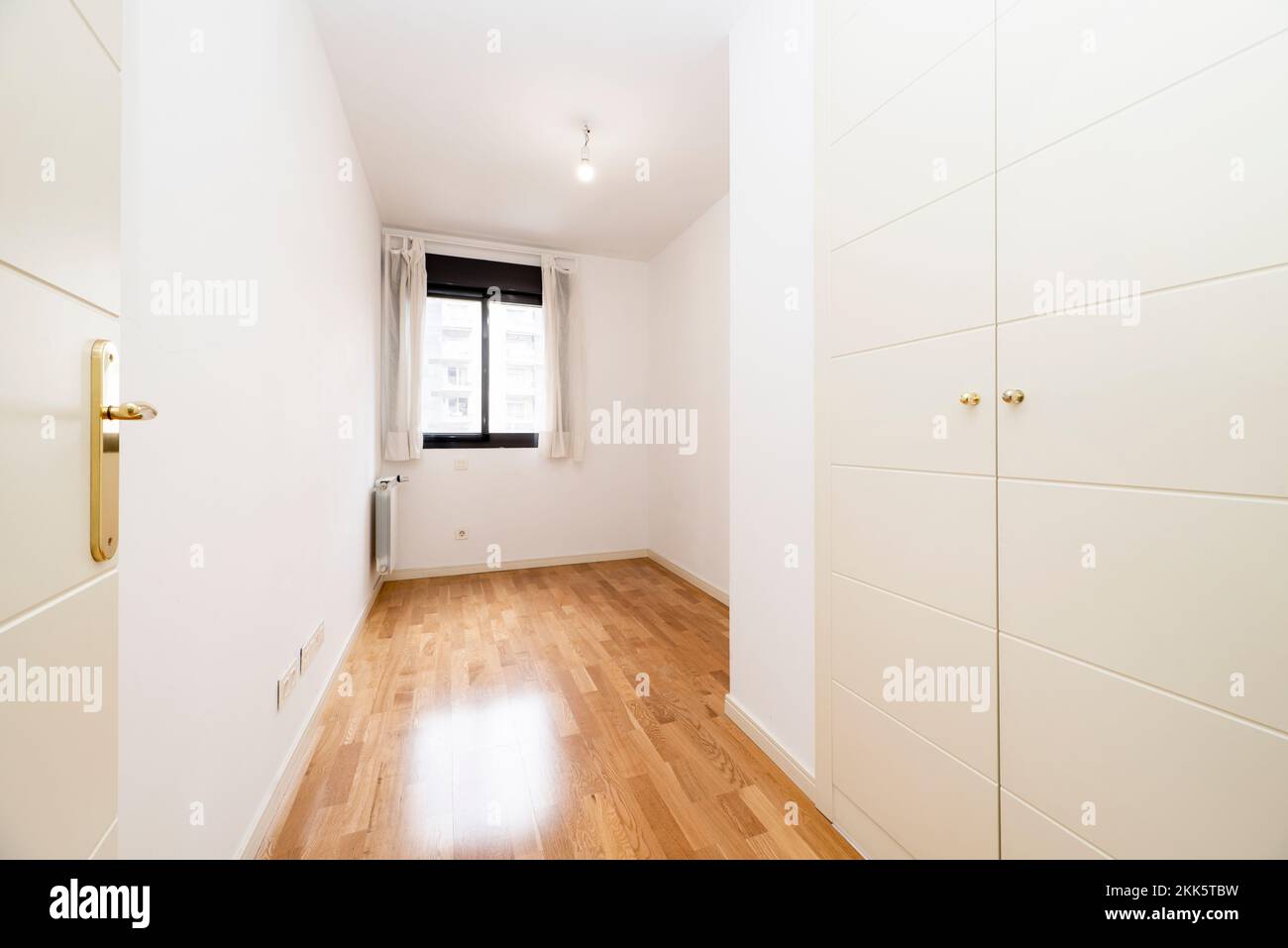 Piccola camera vuota con armadio a muro in legno bianco, finestre in ...