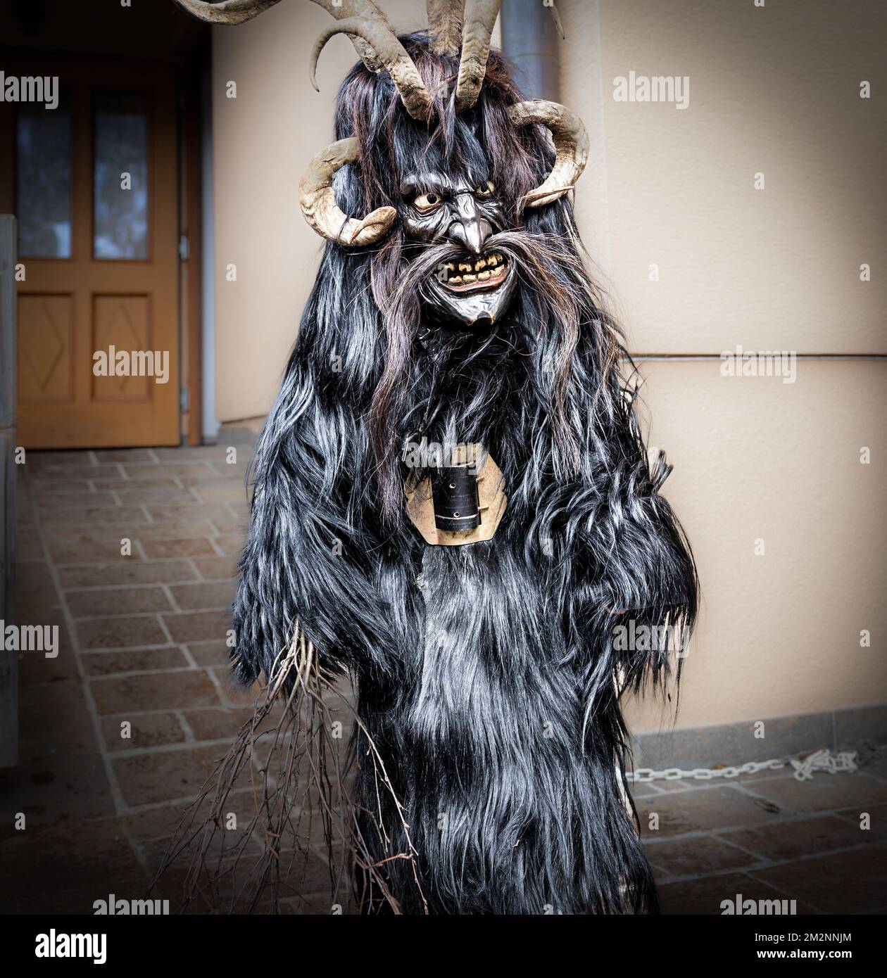 Ritratto di un ragazzo in costume di krampus, pelle di capra nera ...