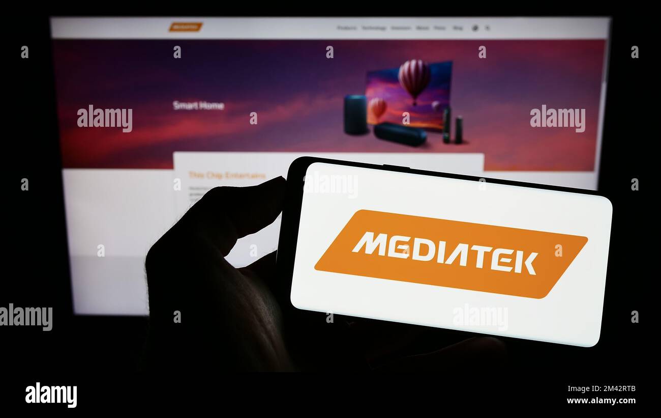 Persona che tiene il cellulare con il logo della società di semiconduttori taiwanese MediaTek ...