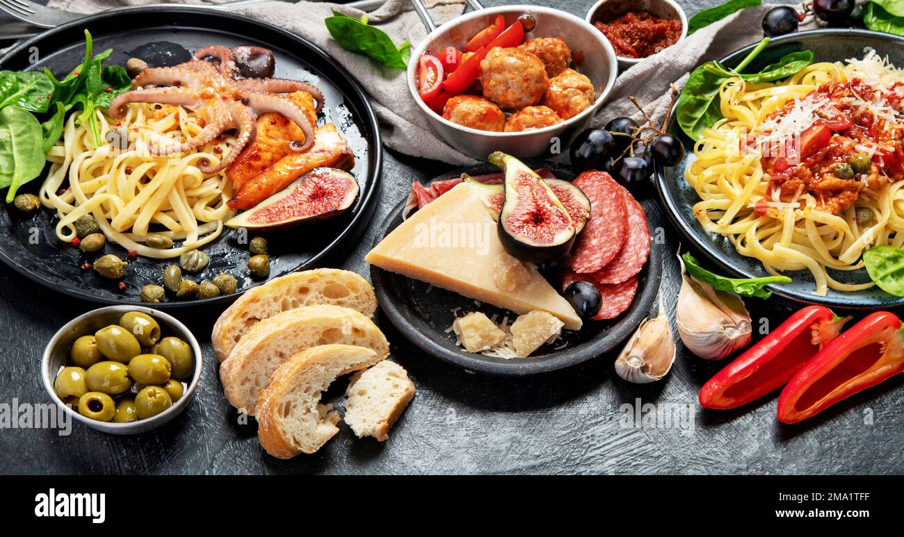 Tavolo da pranzo con piatti italiani. Pizza, pasta, antipasto su sfondo ...