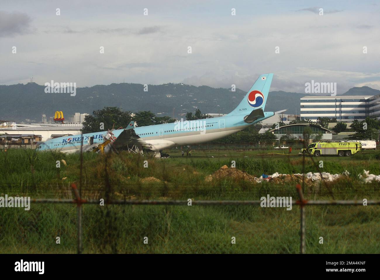 A damaged Korean Air plane lies after it overshot the runway at the Mactan-Cebu International ...