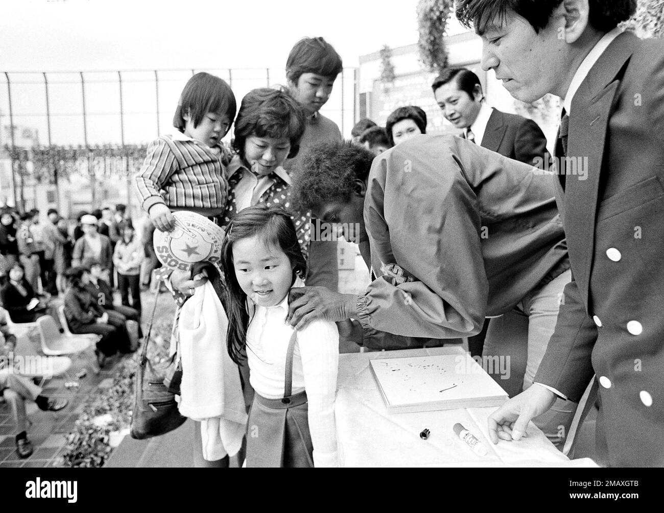 Bob Hayes of the Dallas Cowboys signs his autograph on the back of a ...