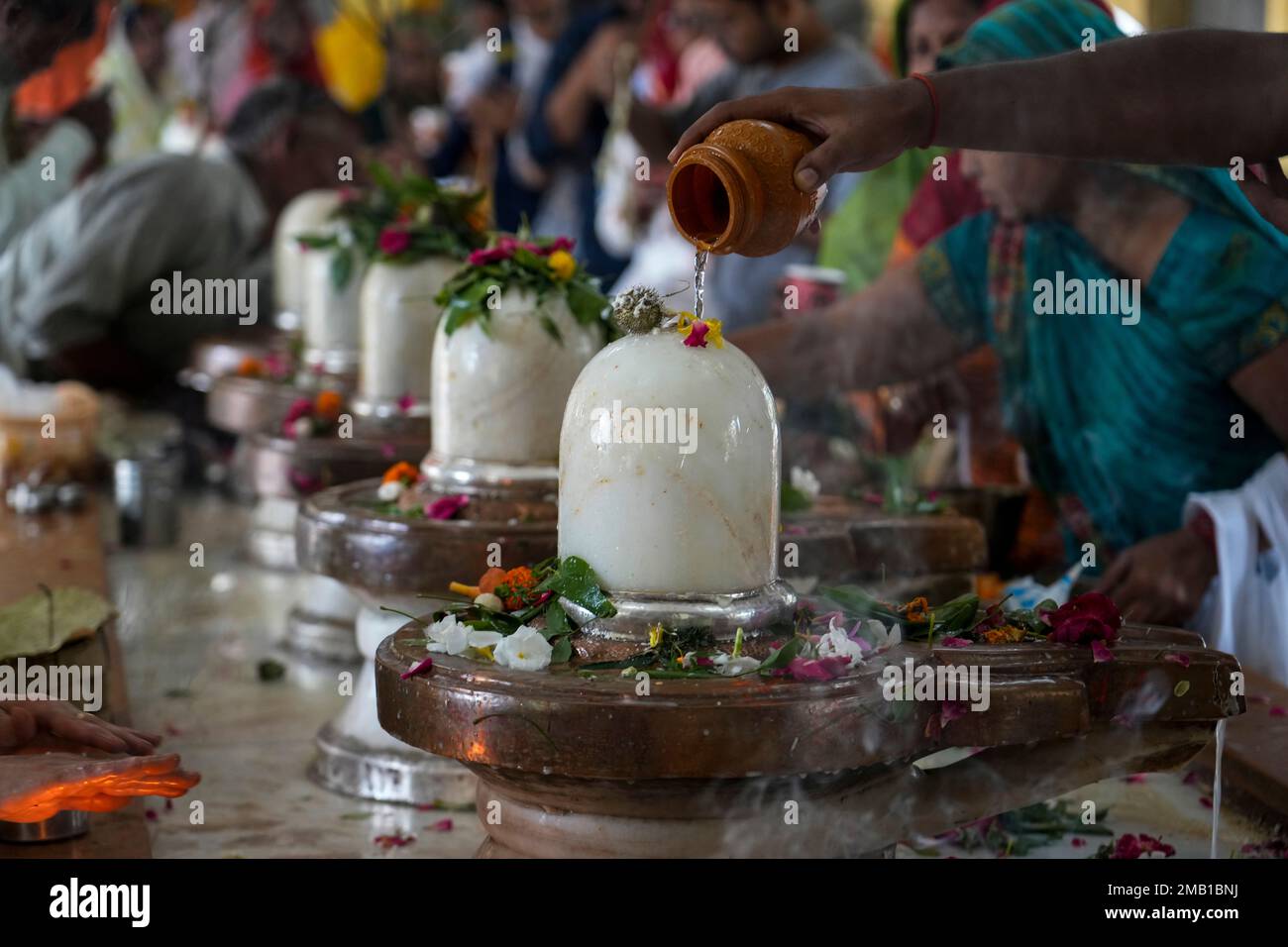 Hindu devotees offer prayers to a row of Shivlings, idols symbolic of ...