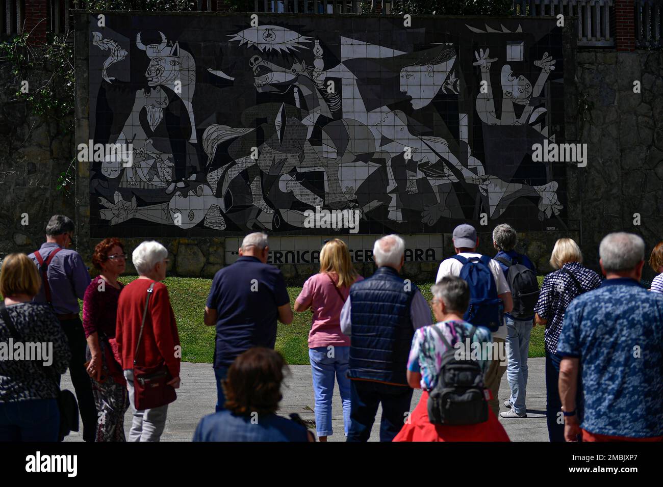 A group of visitors look at a wall with the reproduction of Picasso's ...