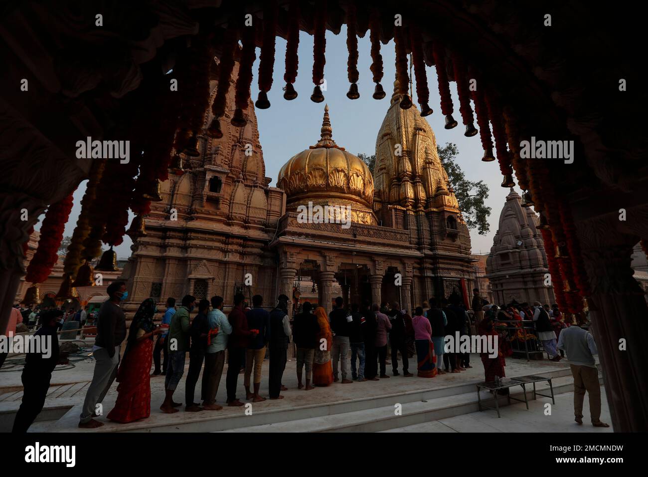 Devotees stand in queue to offer prayers at the Kashi Vishwanath temple dedicated to Lord Shiva ...