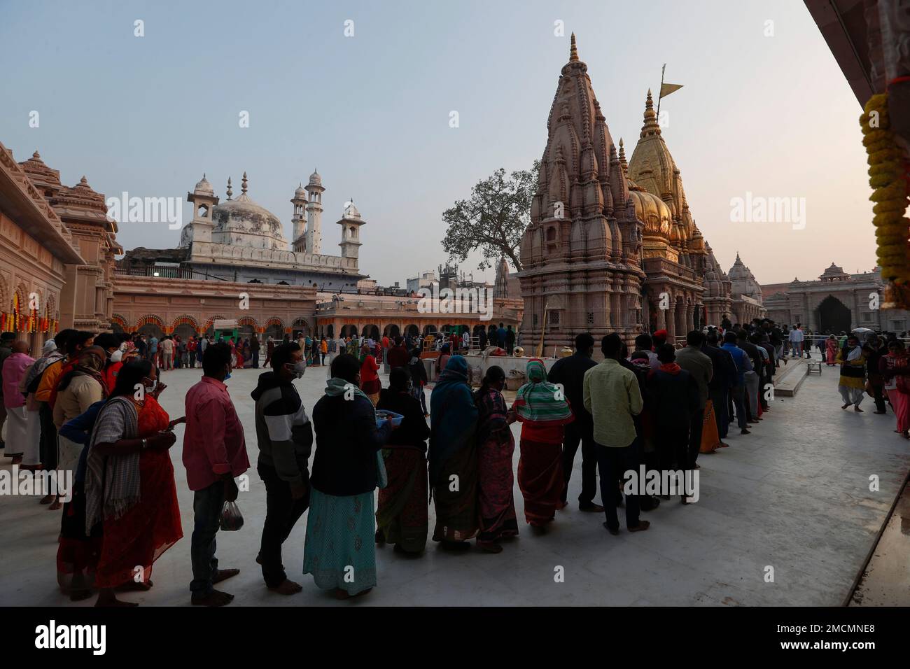 Devotees stand in queue to offer prayers at the Kashi Vishwanath temple dedicated to Lord Shiva ...