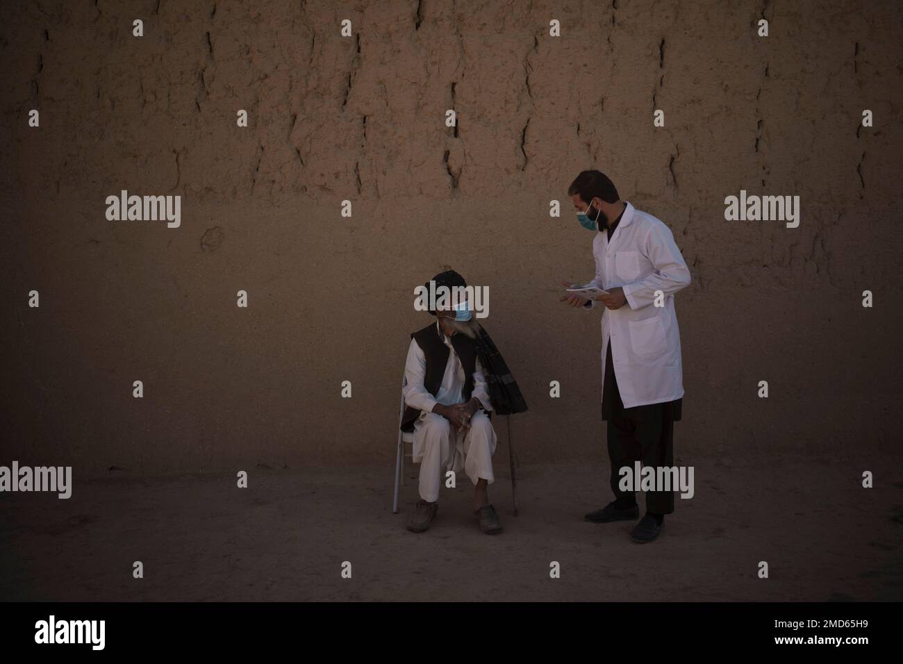 Dr. Obaidullah Ayoubi, right, checks an elderly patient in Utari ...