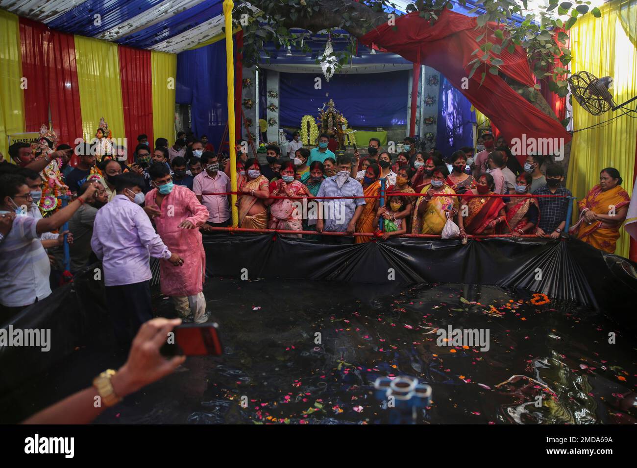 Devotees wait for the immersion of idol of Hindu goddess Durga next to ...