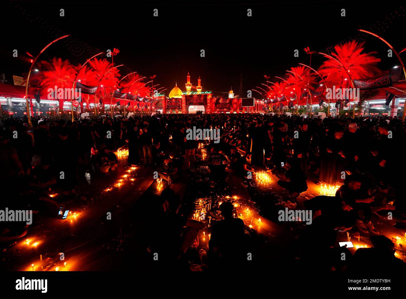 Shiite faithful pilgrims light candles outside the holy shrine of Imam ...