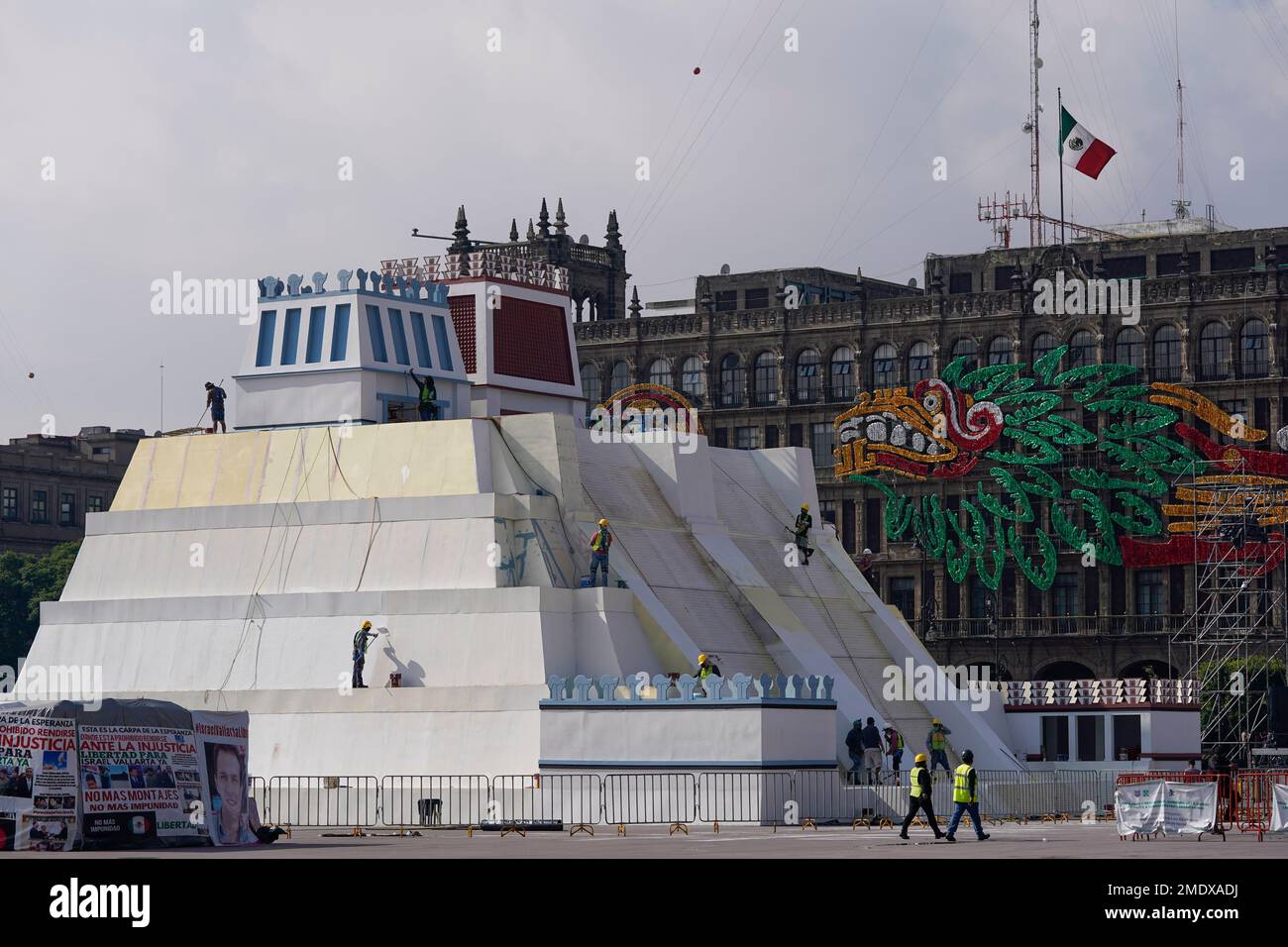Workers build a replica of the Aztec Templo Mayor, with an image of the ...