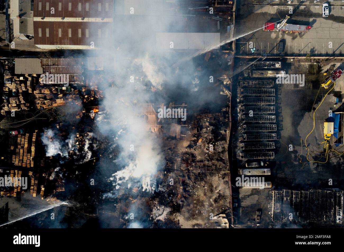 in this photo taken by a drone, firefighters battle a fire at a ...