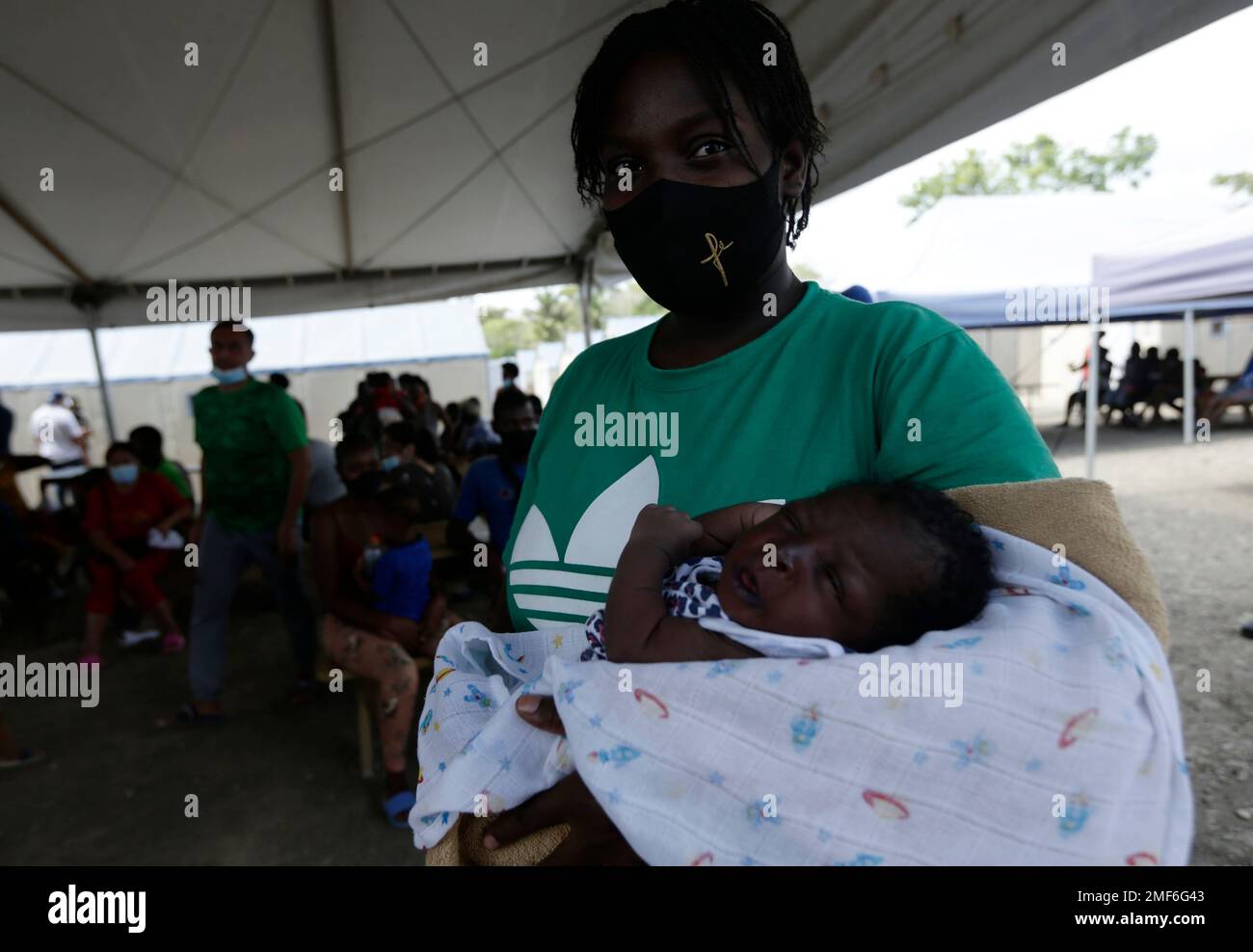 A Haitian migrant holds her baby as she waits for medical attention at ...