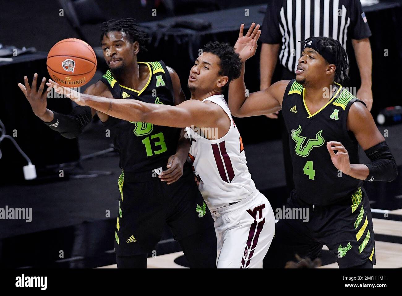 Virginia Tech's Keve Aluma, center, reaches between South Florida's ...