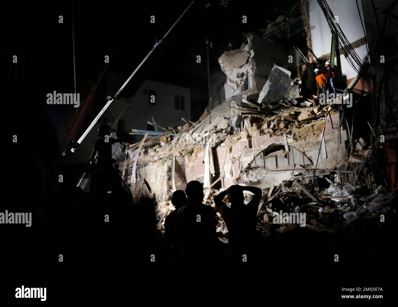 Lebanese and Chilean rescuers search the site of a collapsed building ...