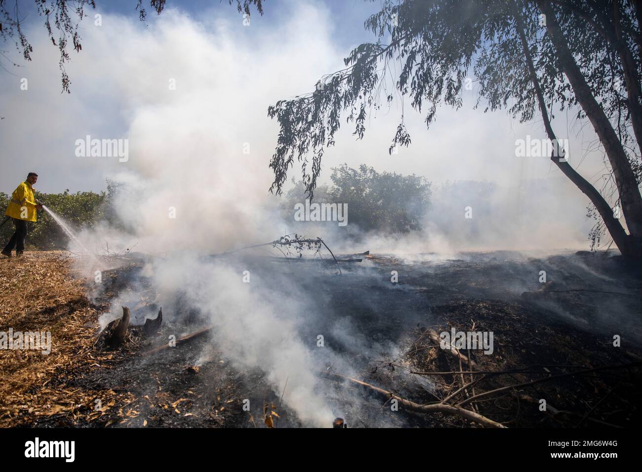 A firefighter attempts to extinguish a fire started by an incendiary ...
