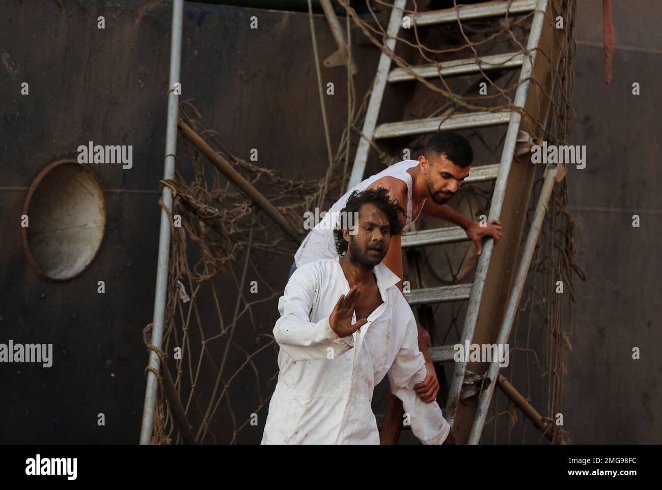 A choked sailor, foreground, evacuates a ship which dock near the ...
