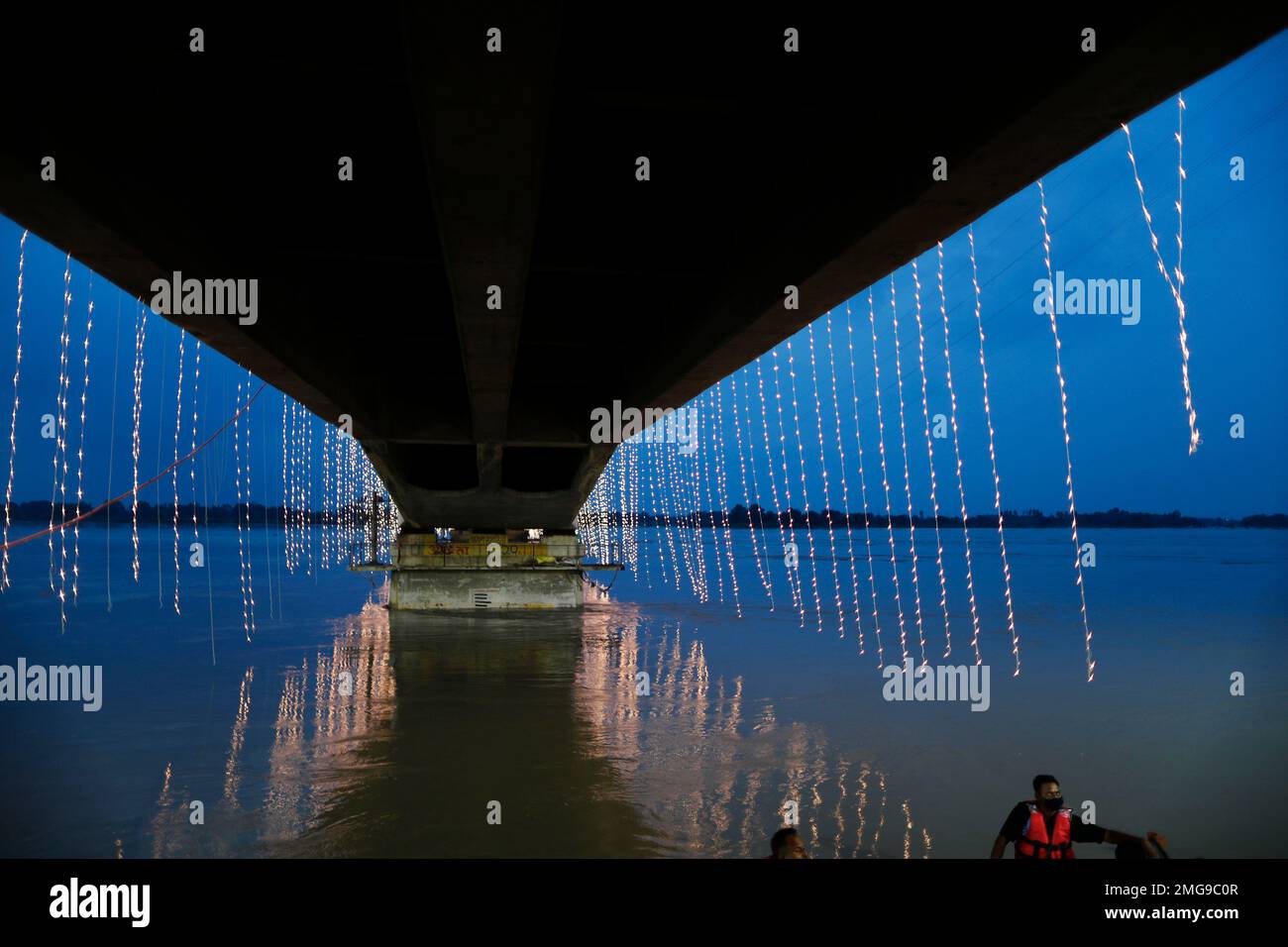 A life guard keeps a vigil under a decorated bridge over the river ...