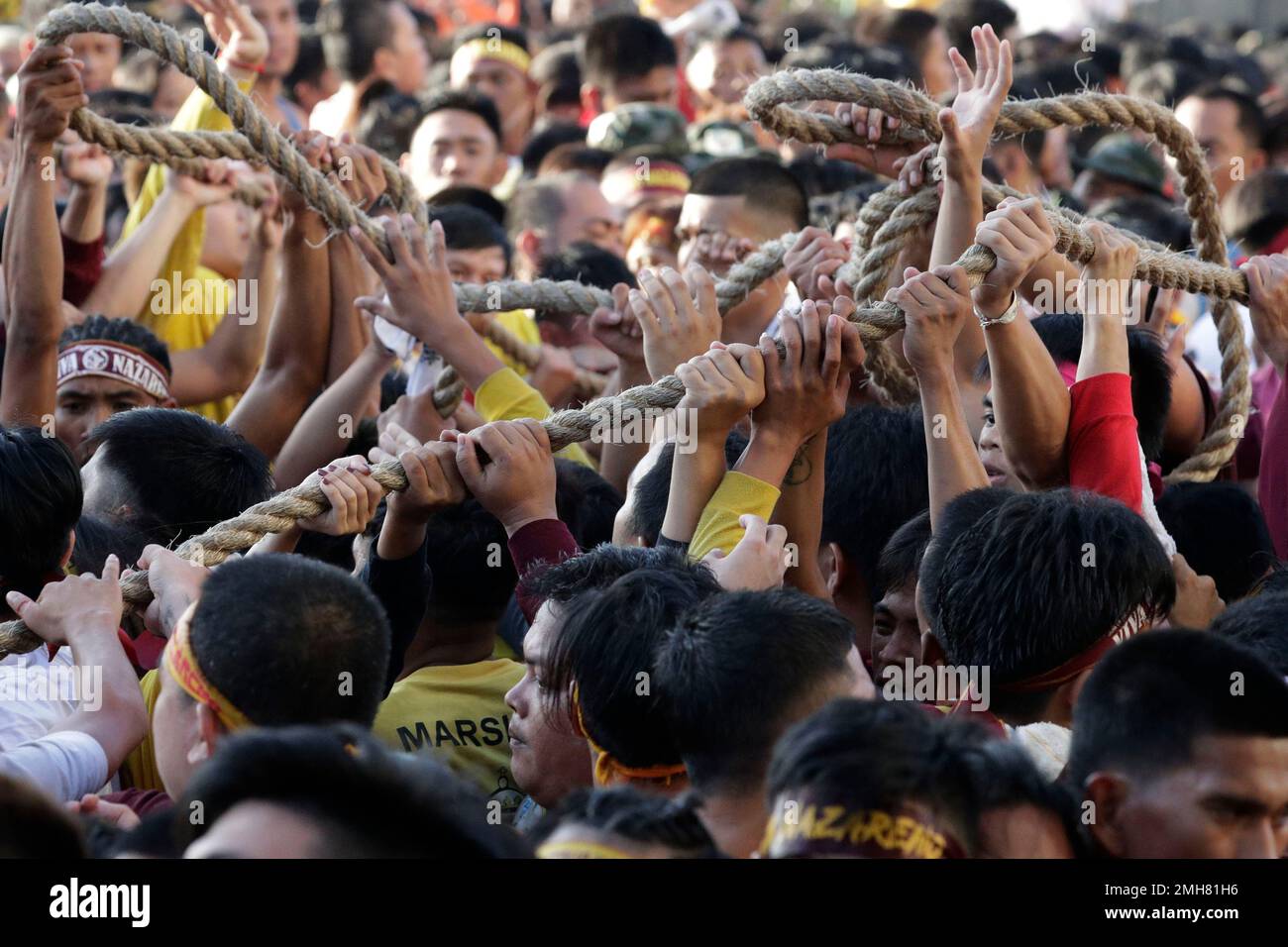 Filipino Roman Catholic devotees jostle to get the rope that pulls the ...
