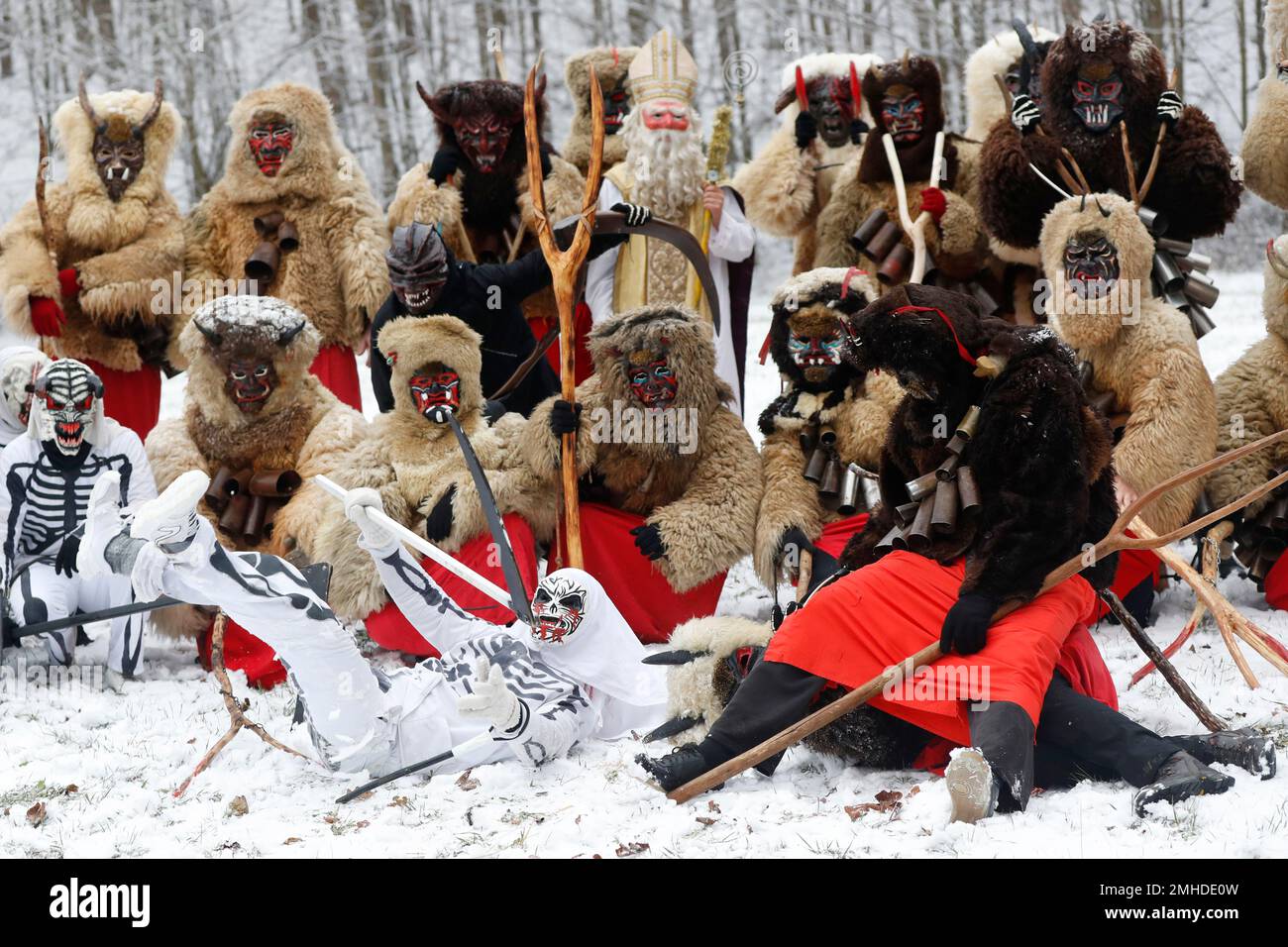 Revelers depicting grim reapers and devils pose for a photo during a ...