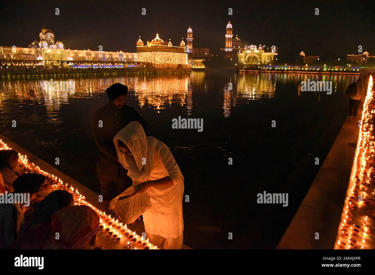 Sikhs light candles at the Golden Temple, the holiest of Sikh shrines on the birth anniversary ...