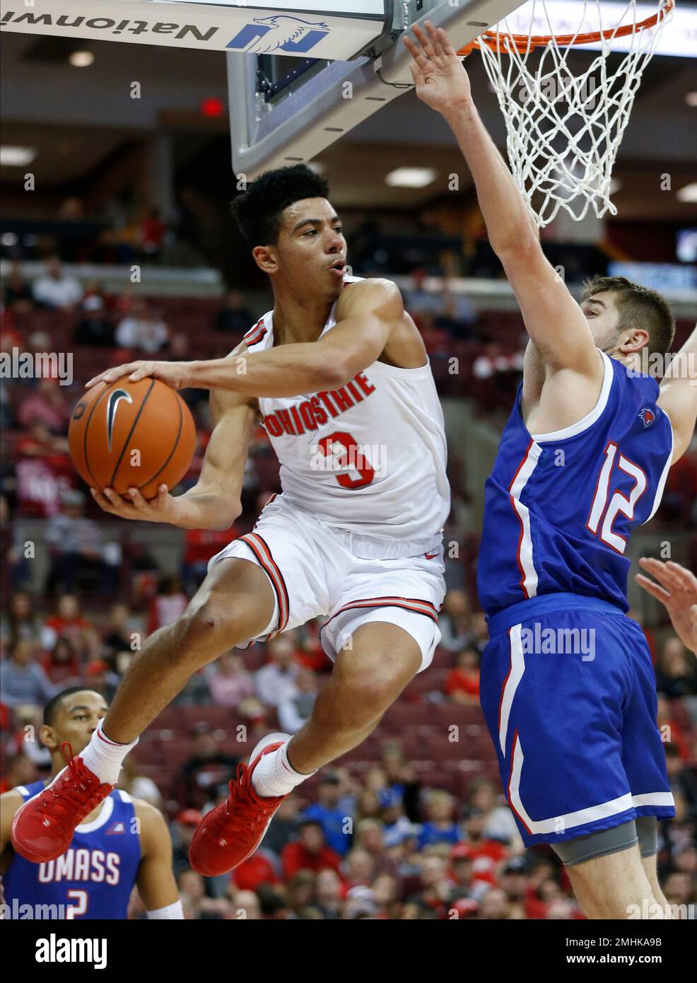 Ohio State's D.J. Carton, left, looks to pass the ball as Massachusetts ...