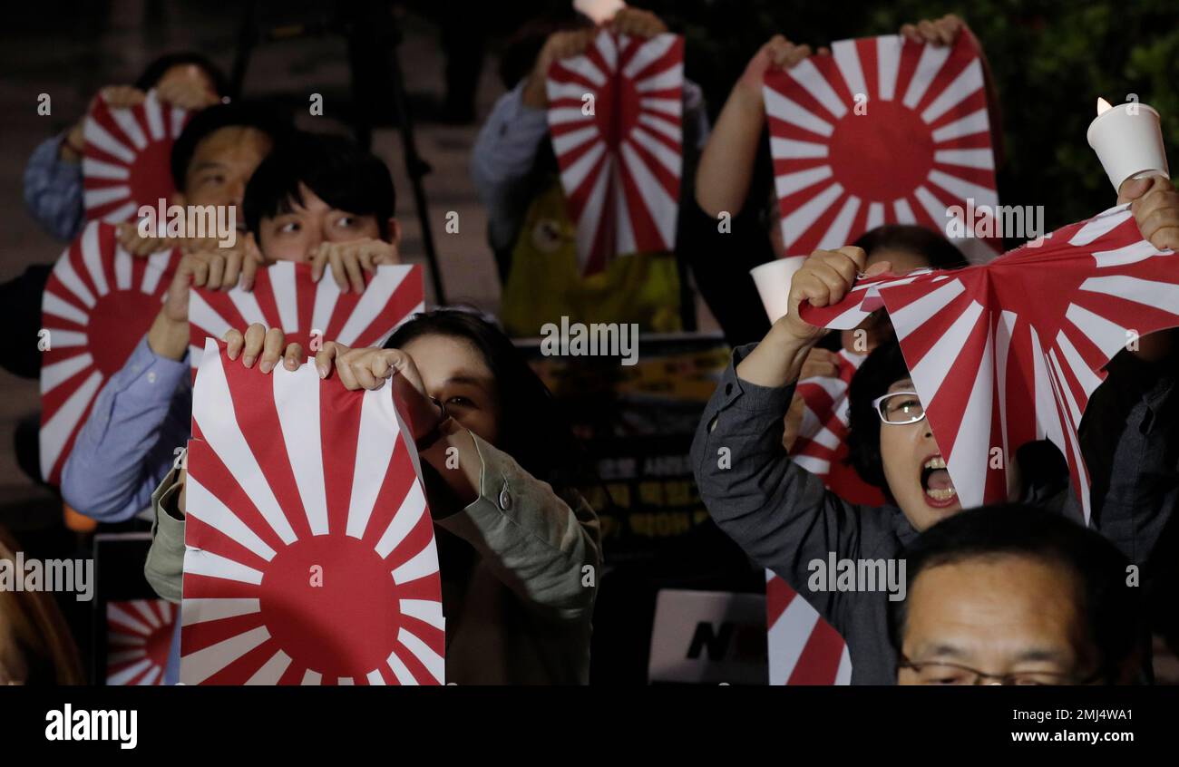 South Korean protesters tear Japanese rising sun flags during a rally ...