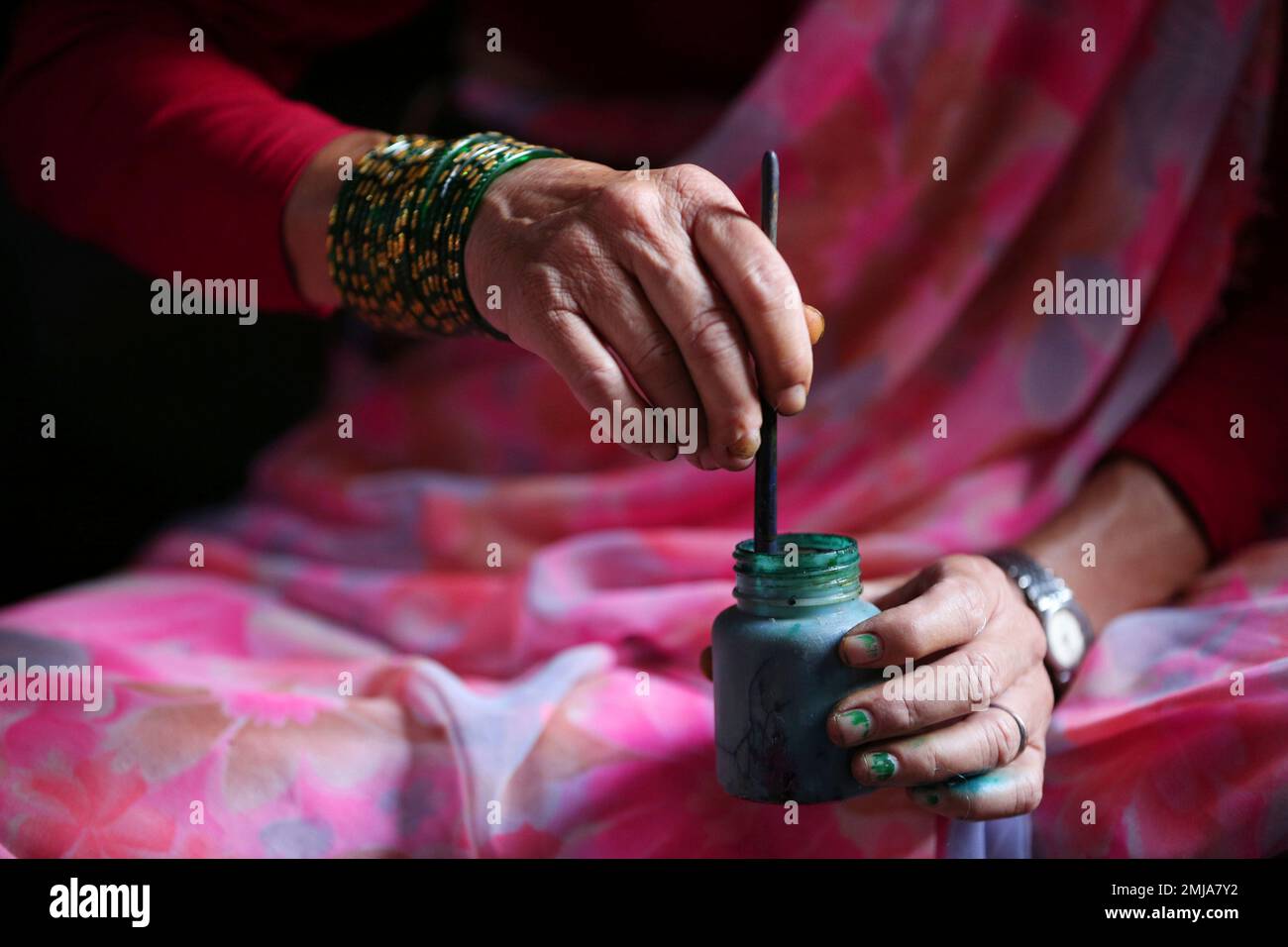 In this July 31, 2019, photo, Tej Kumari Chitrakar mixes color to make ...