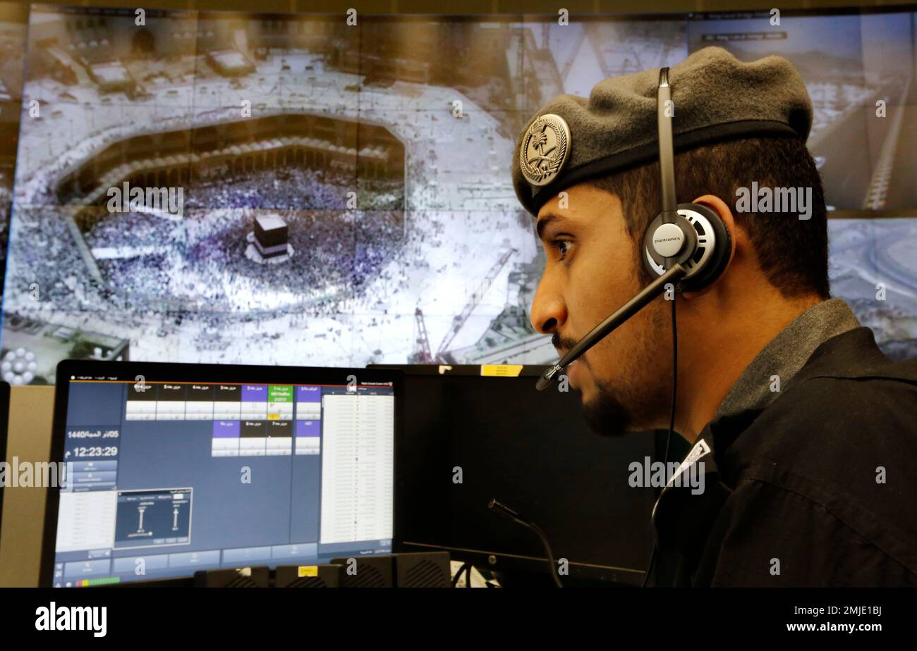 A Saudi police officer monitors screens displaying the Grand Mosque, at ...