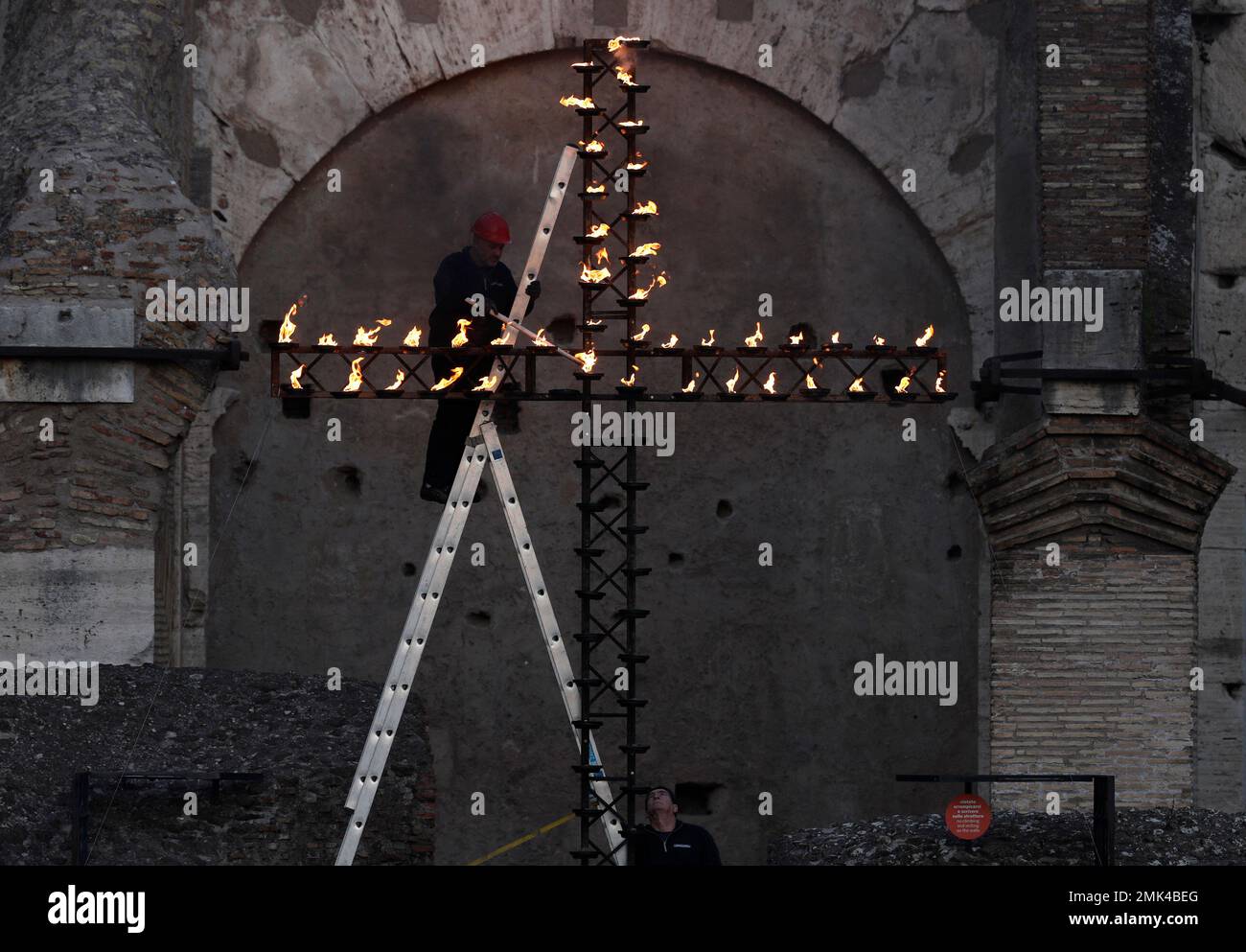 Workers light up the cross at the start of the Via Crucis (Way of the ...