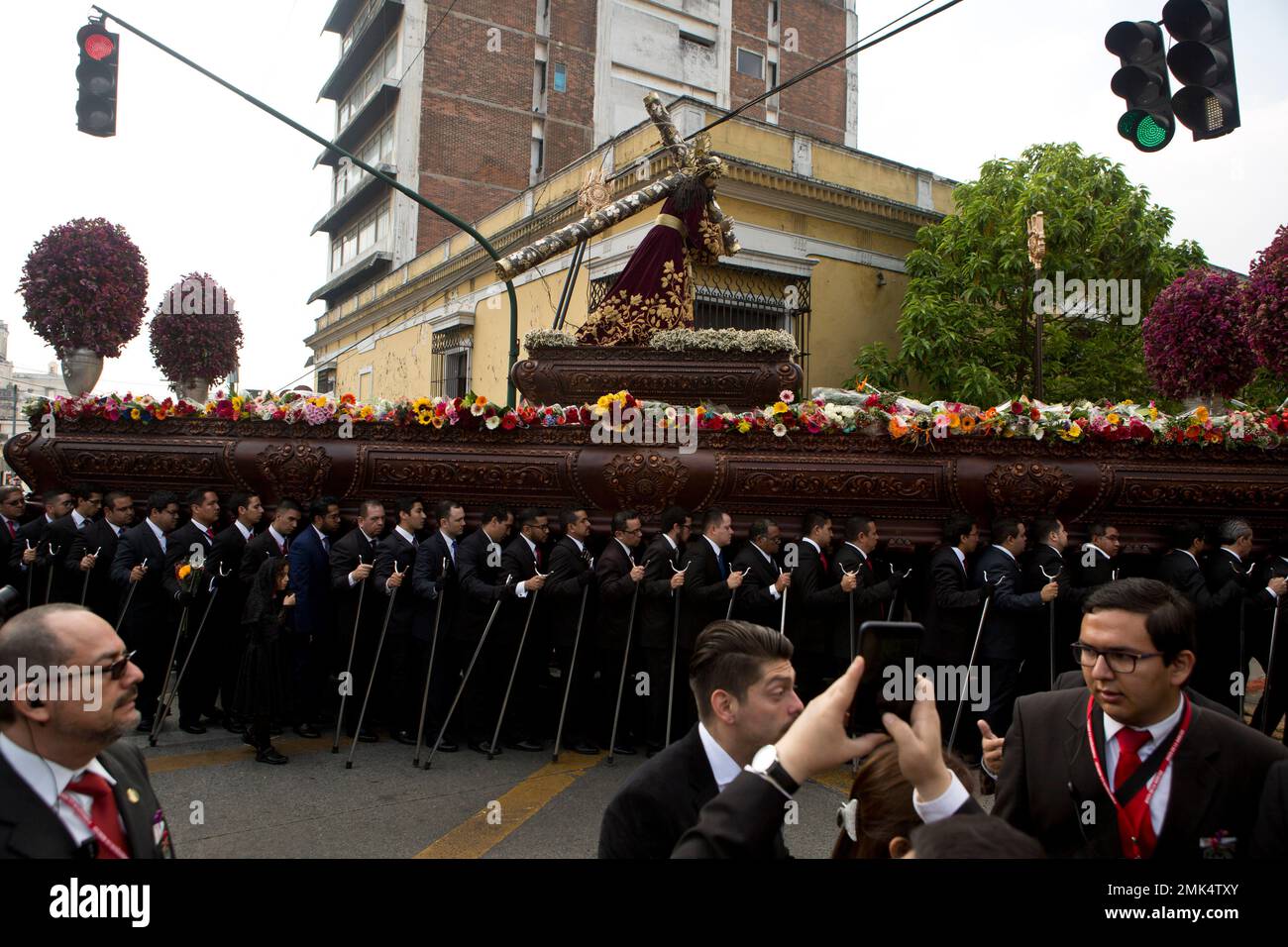 Carriers, known as "cucuruchos," carry a wooden platform with a Jesus ...