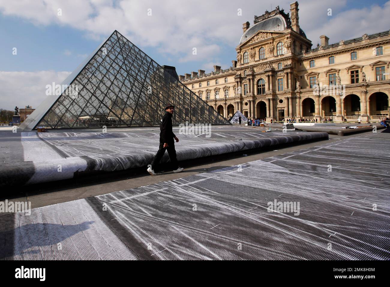 French street artist JR walks in the courtyard of the Louvre Museum ...