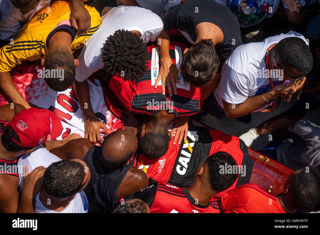Friends and relatives of Christian Esmerio Candido gather around his ...