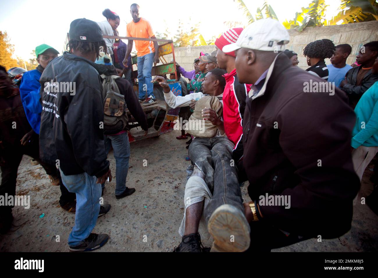 People carry man to the tap-tap truck that serves as a public bus ...