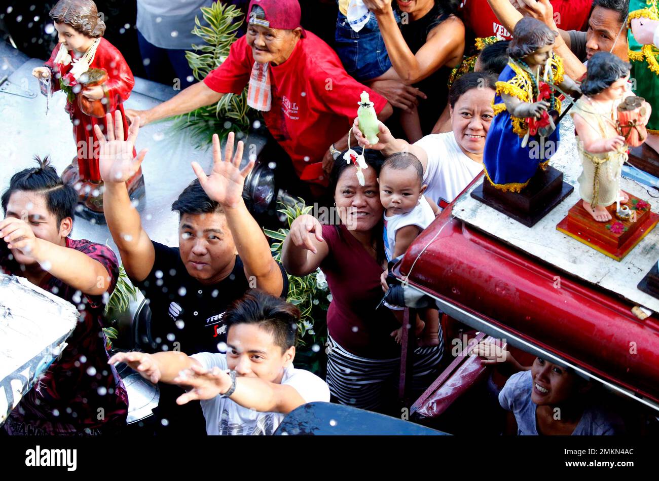 Roman Catholic devotees raise images of the Child Jesus, known as Santo ...