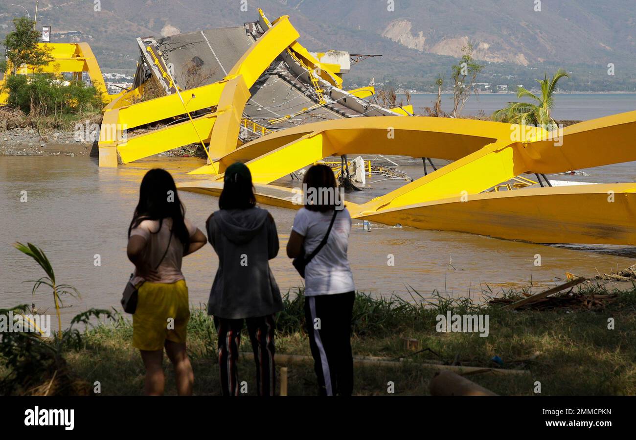 In this Oct. 4, 2018, photo, villagers look at the damage on the city's ...