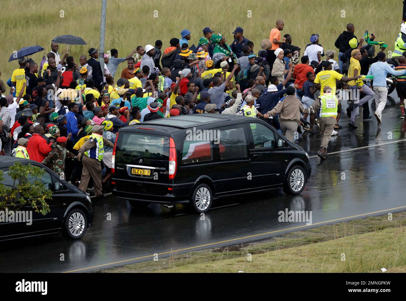 People follow the hearse carrying the coffin of anti-apartheid activist ...