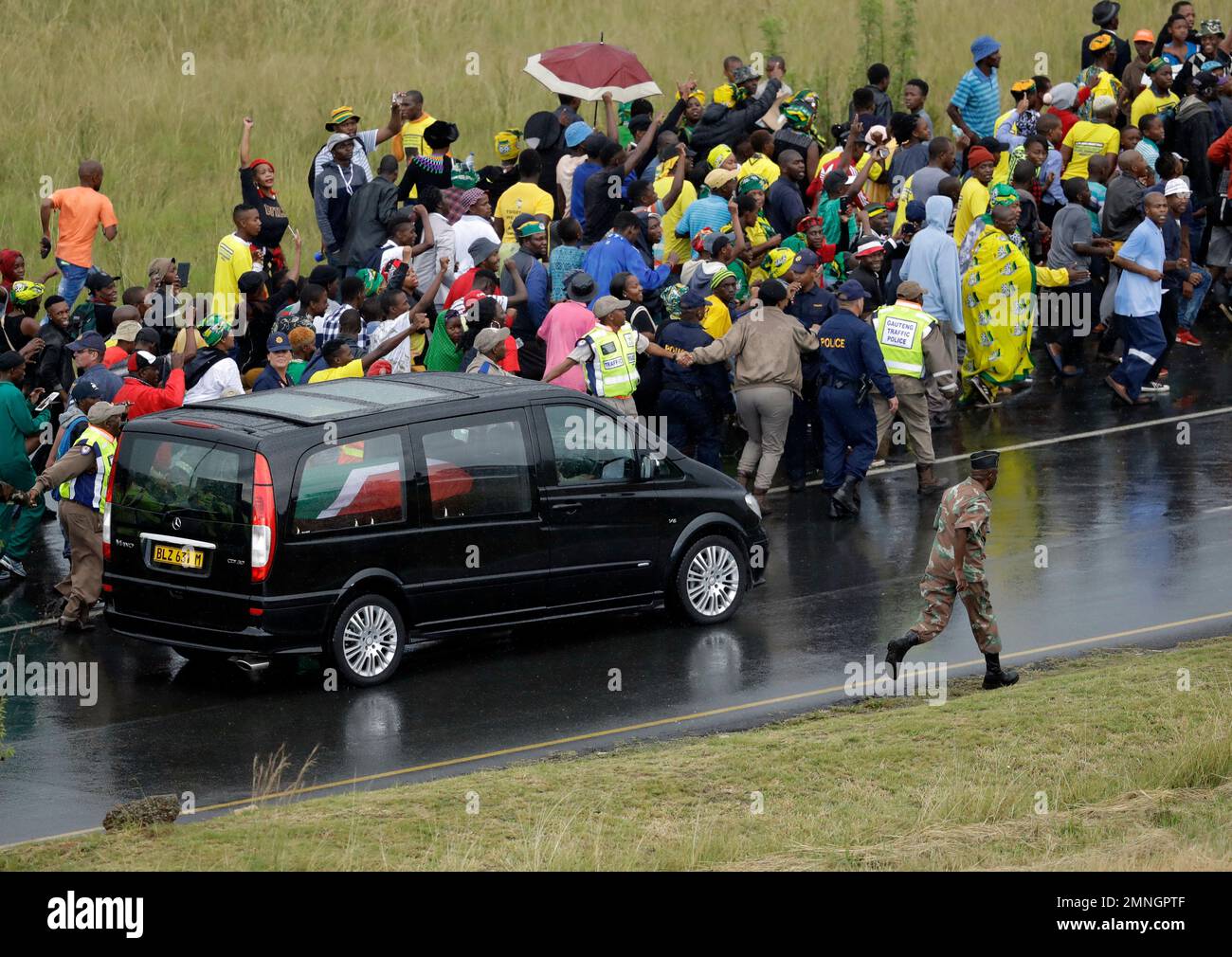 People follow the hearse carrying the coffin of anti-apartheid activist ...