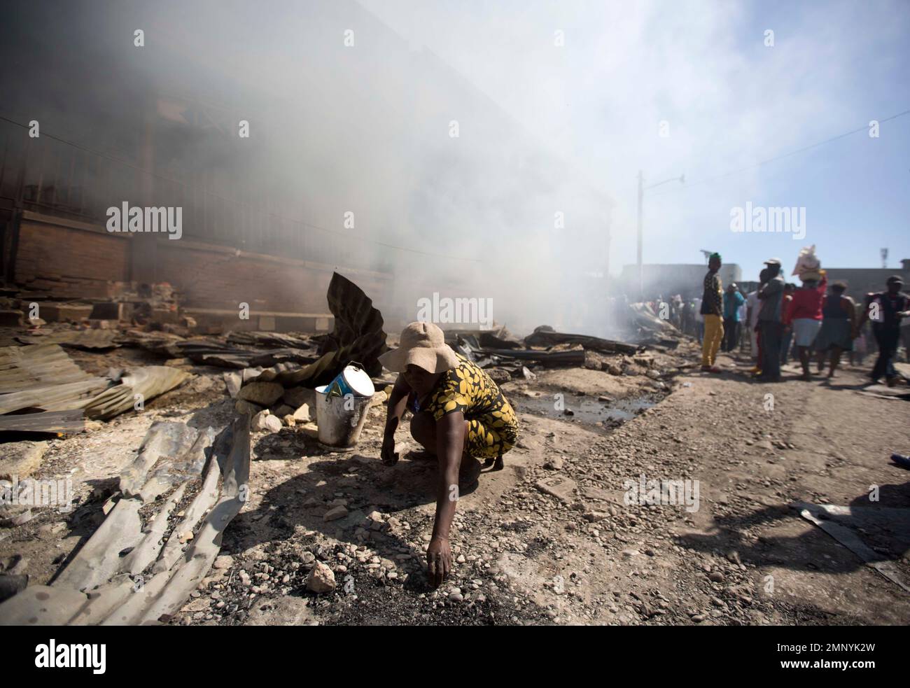 A woman looks for salvageable items in the aftermath of a fire that ...