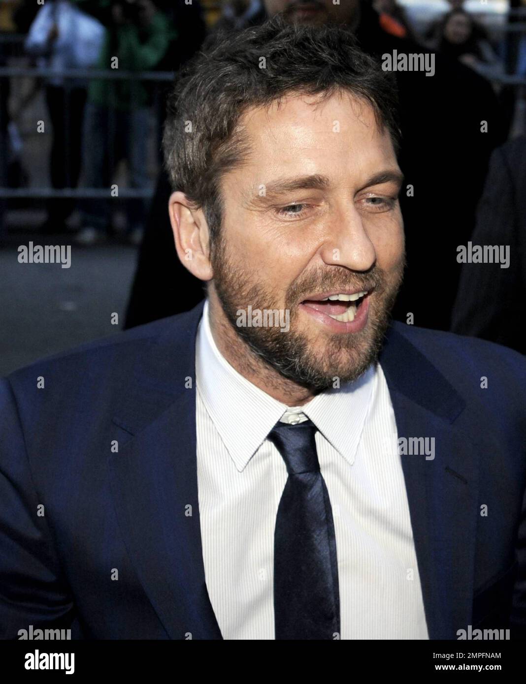 Gerard Butler sorride mentre saluta i fan e firma autografi al di fuori ...