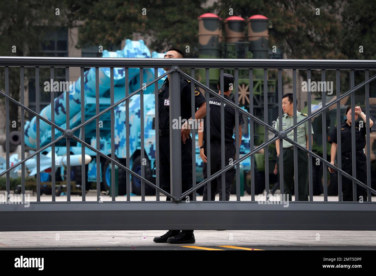A security guard looks out from a main entrance gate of the closed ...