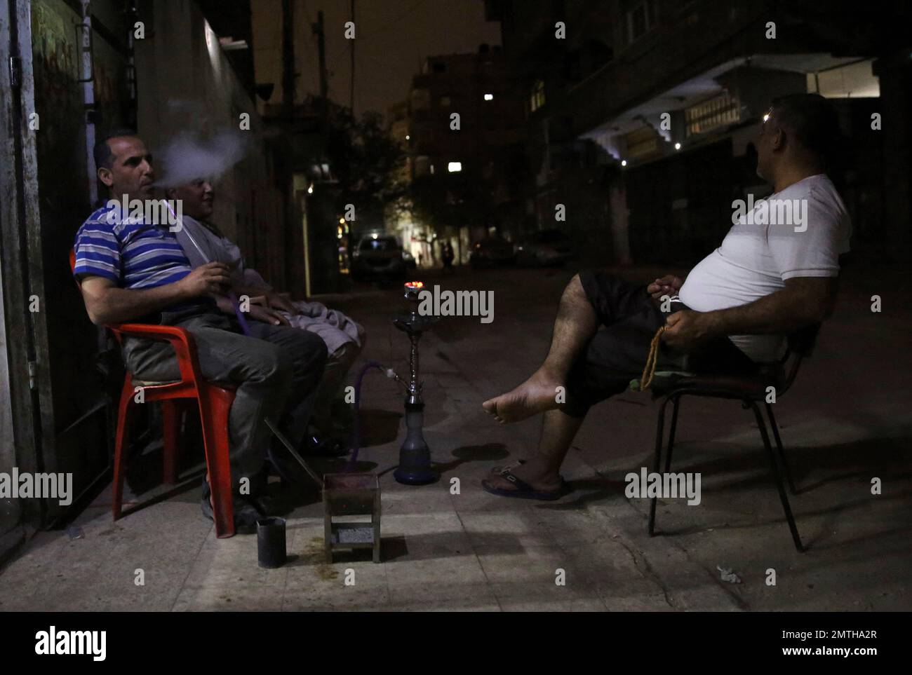 In this Tuesday, May 30, 2017 photo, men share a water pipe during a ...