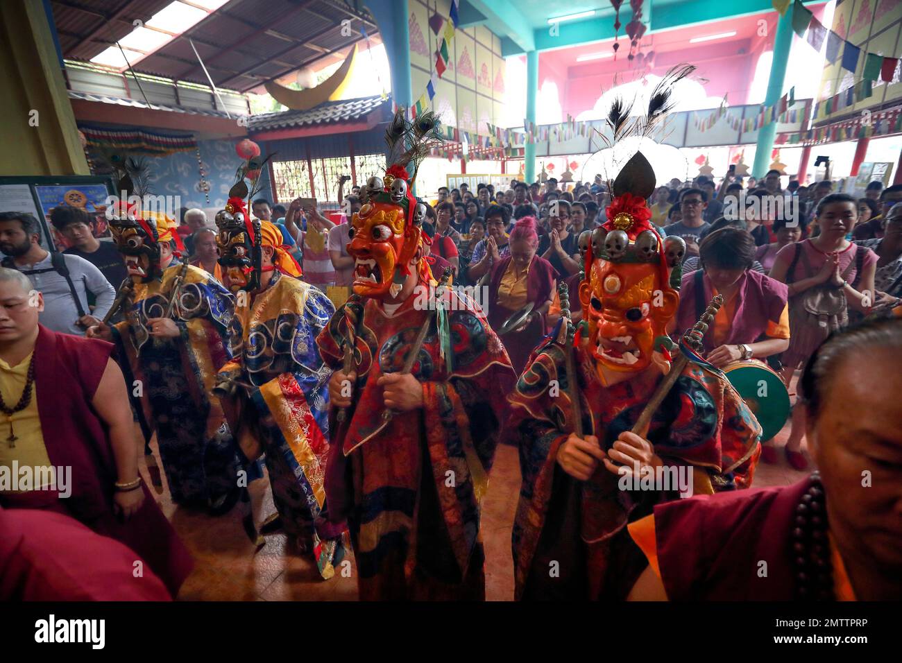 Monks wearing magnificent costumes and masks perform prayers before the ...