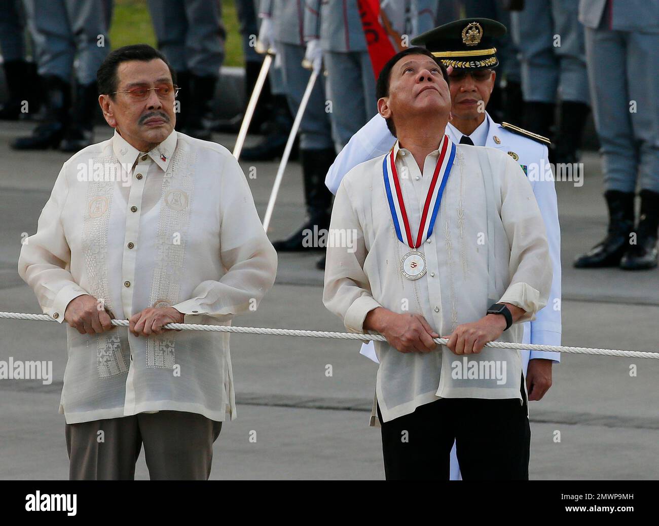 Philippine President Rodrigo Duterte, right, looks up as he leads the ...