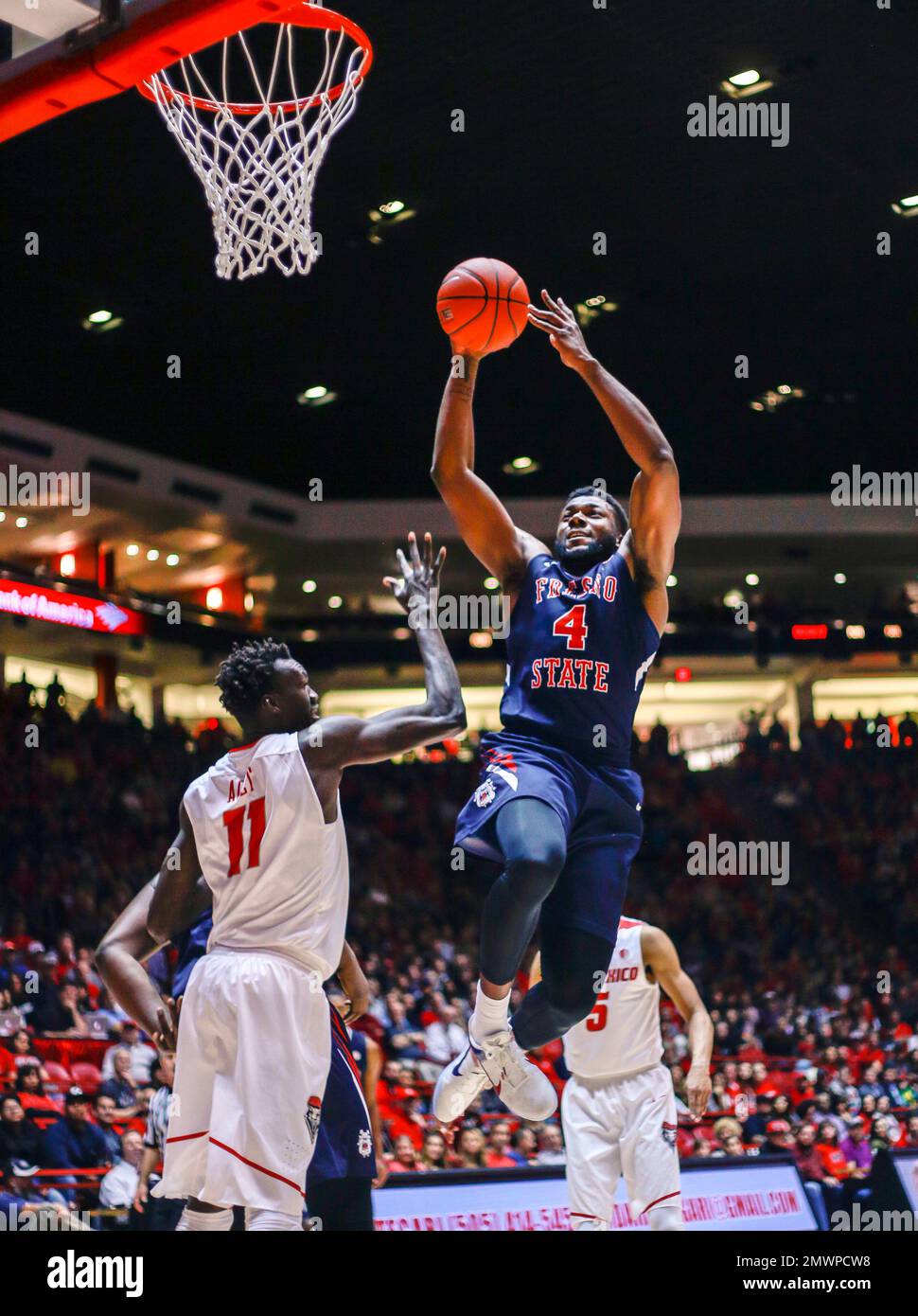Fresno State's Karachi Edo (4) goes up for a dunk over New Mexico's ...