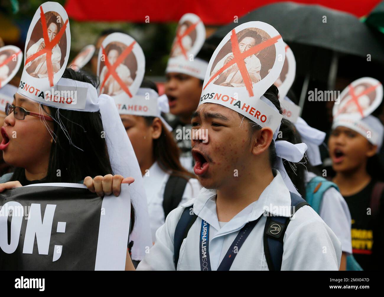Students shout slogans as they burn an effigy of the late Philippine ...