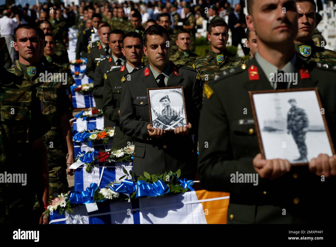 Greek soldiers carrying the coffins and the photographs of the Greek ...
